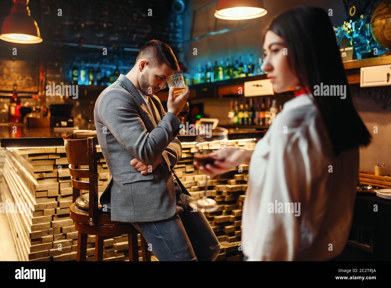 Sad man and woman in a bar, husband and wife relaxing together in ...