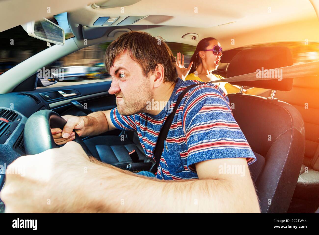 Angry man driving the car, woman on the back seat is scared Stock Photo ...