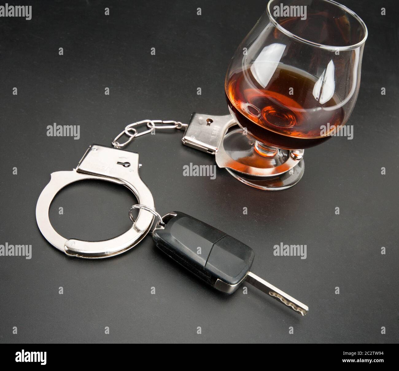 Car key locked to glass of alcohol by handcuffs Stock Photo - Alamy