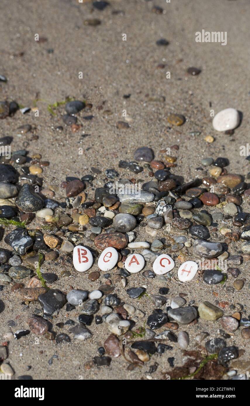 word beach written on pebbles and waters edge on a beach Stock Photo ...