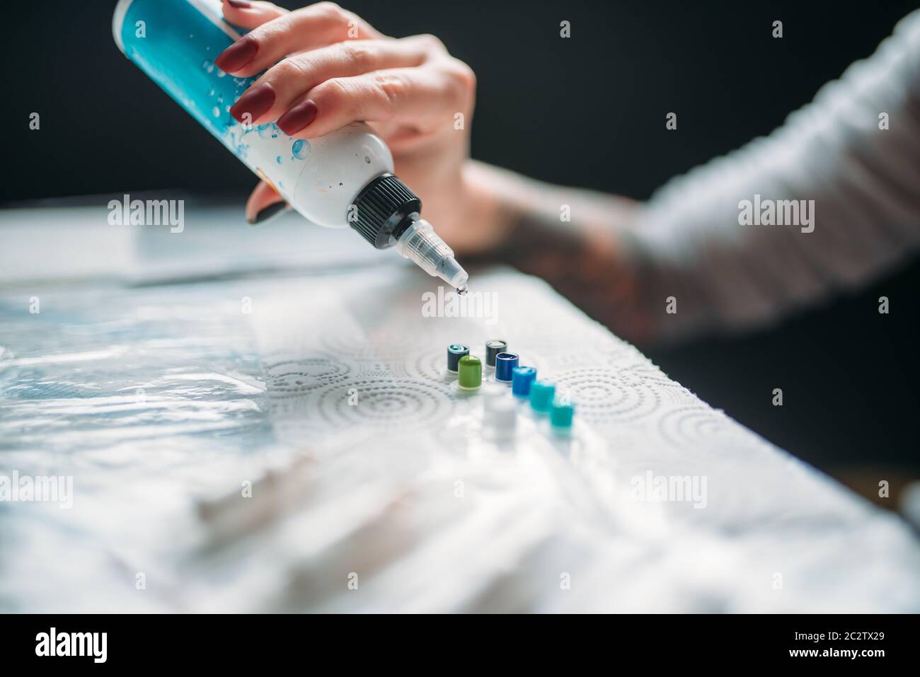 Female tattooist hand with bottle of color ink. Preparation for ...
