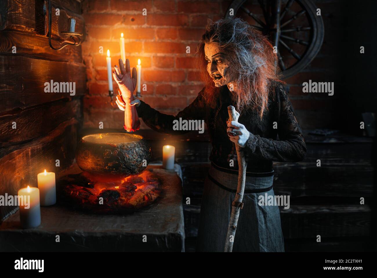 Scary witch reads spell over the pot with human body parts, dark powers ...