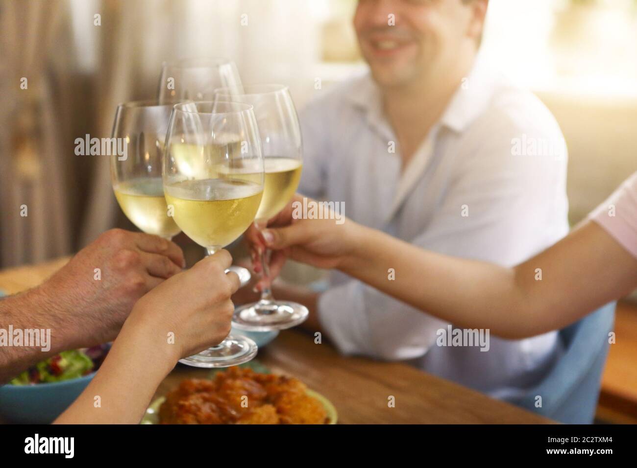 Hands of a group of people cheering with white wine Stock Photo - Alamy
