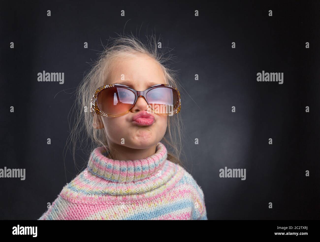 Cute little girl in sunglasses is making face Stock Photo - Alamy