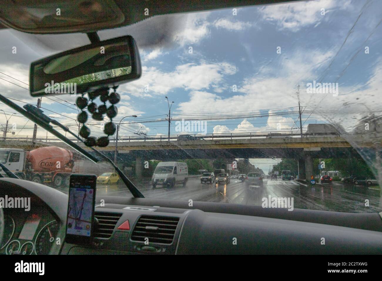 Traffic in rainy day with road view through car window with rain drops ...