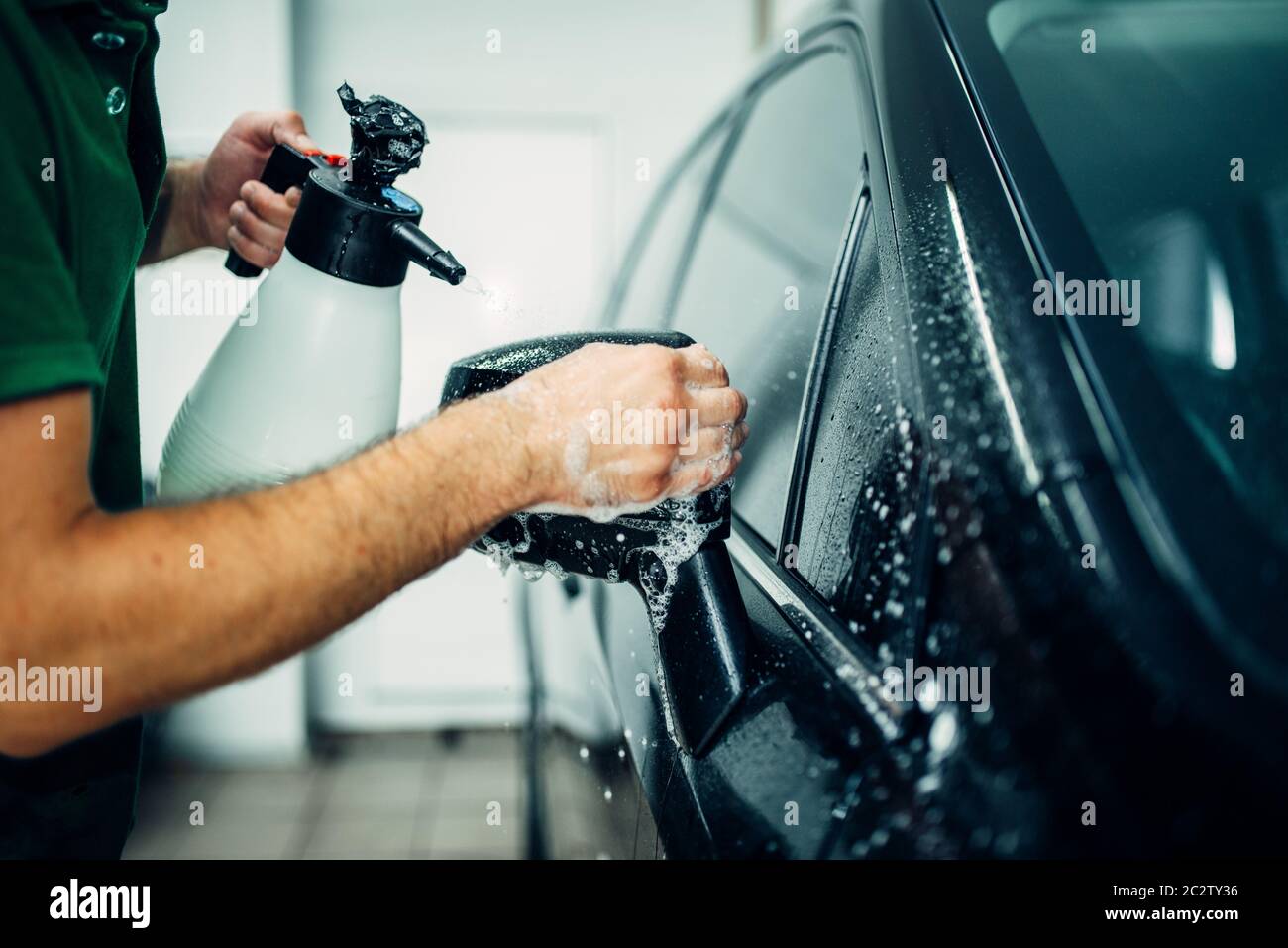 Preparing car, protect against chips and scratches. Worker disperses ...