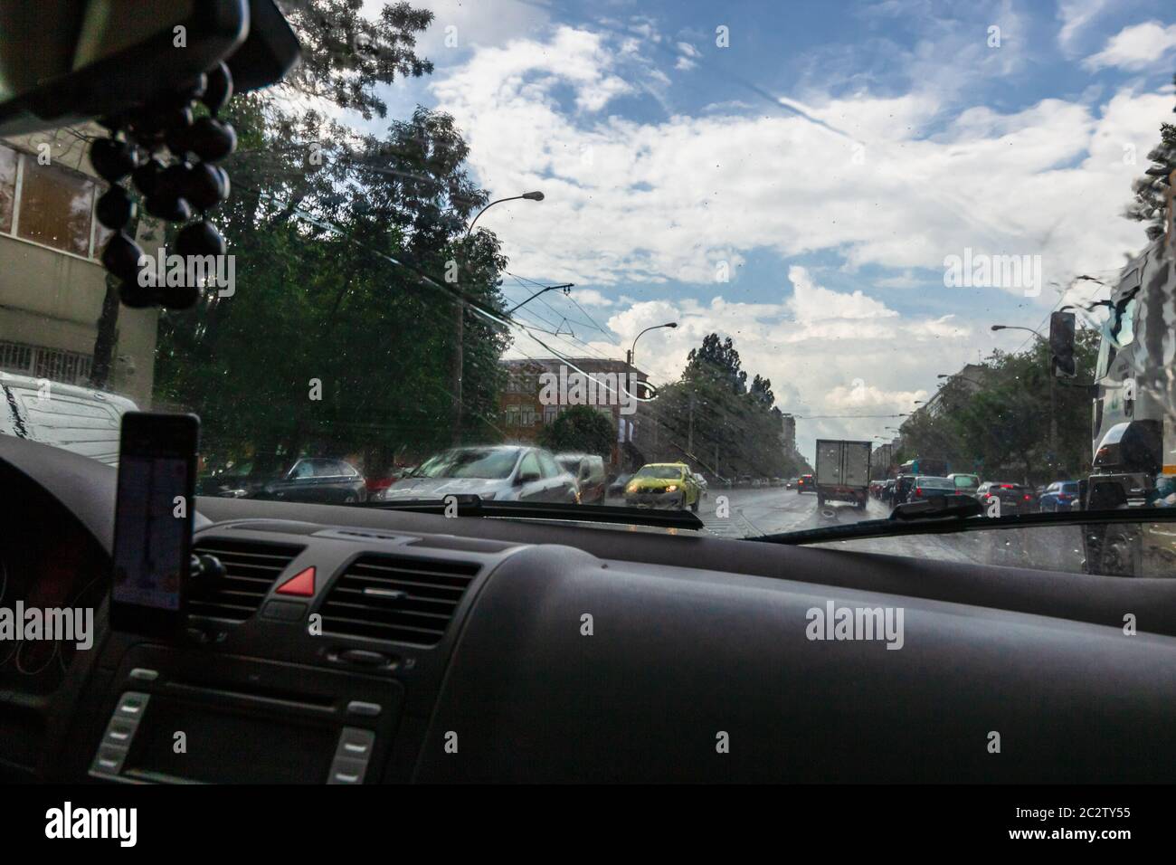 Traffic in rainy day with road view through car window with rain drops ...