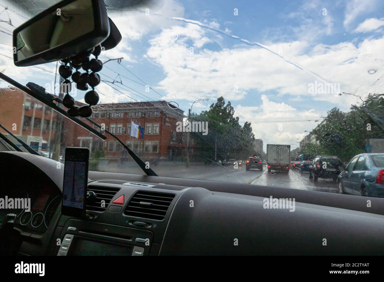 Traffic in rainy day with road view through car window with rain drops ...