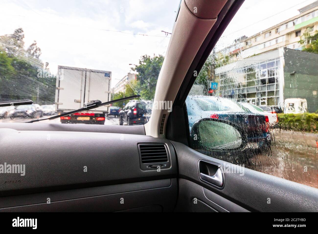 Traffic in rainy day with road view through car window with rain drops ...
