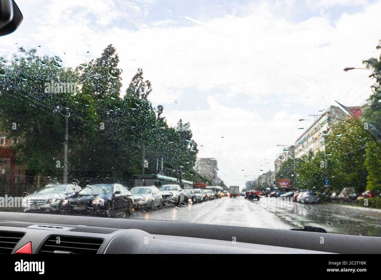 Traffic in rainy day with road view through car window with rain drops ...