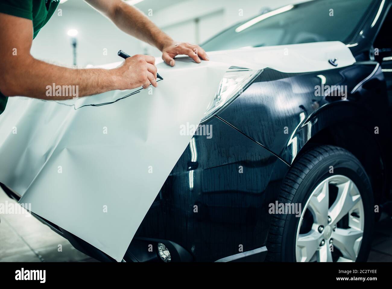 Automobile paint protection film installation process. Worker hands ...