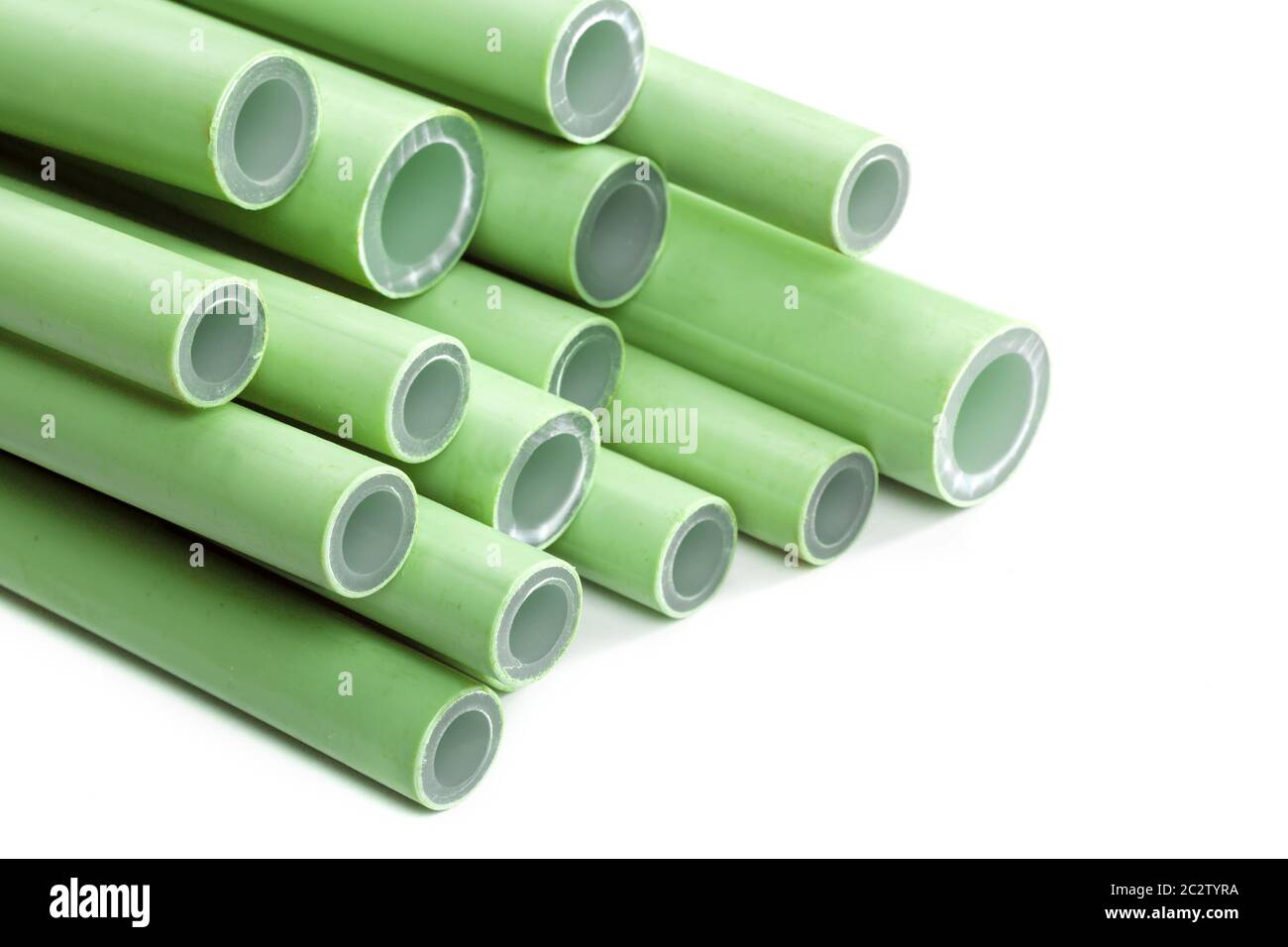 Pile of green plastic pipes on white Stock Photo - Alamy