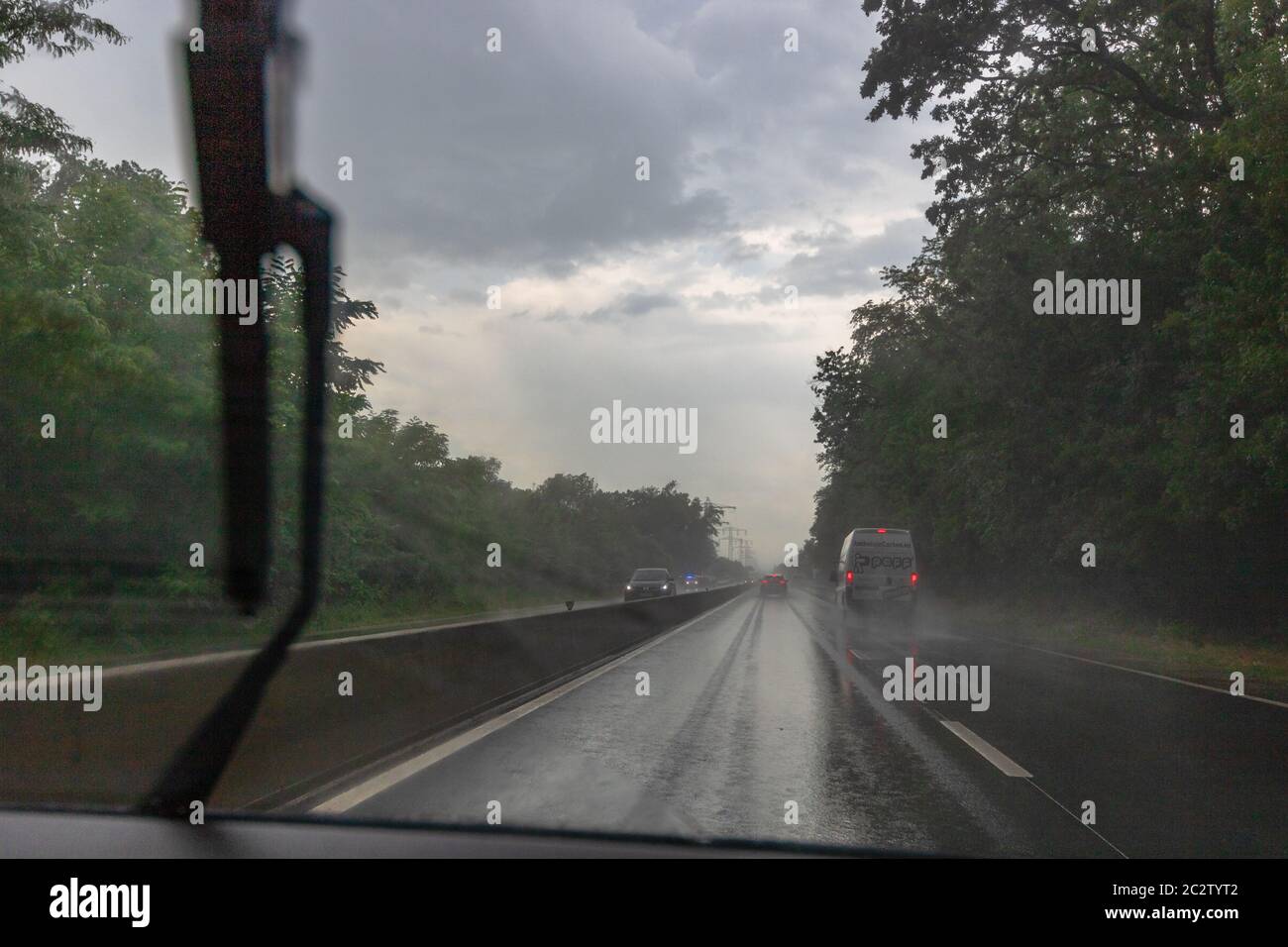 Traffic in rainy day with road view through car window with rain drops ...