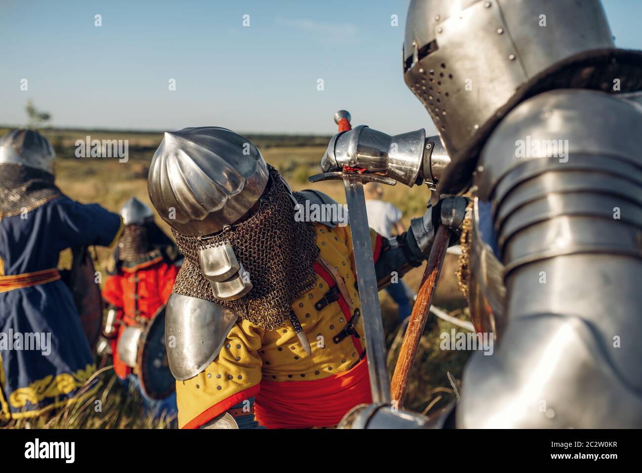 Medieval knights in armor and helmets fight with sword and axe. Armored ...