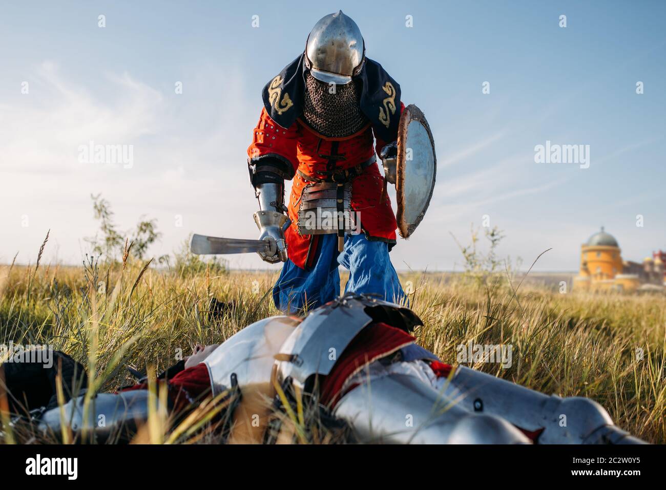 Medieval knight in armor and helmets put his sword to his opponent's ...