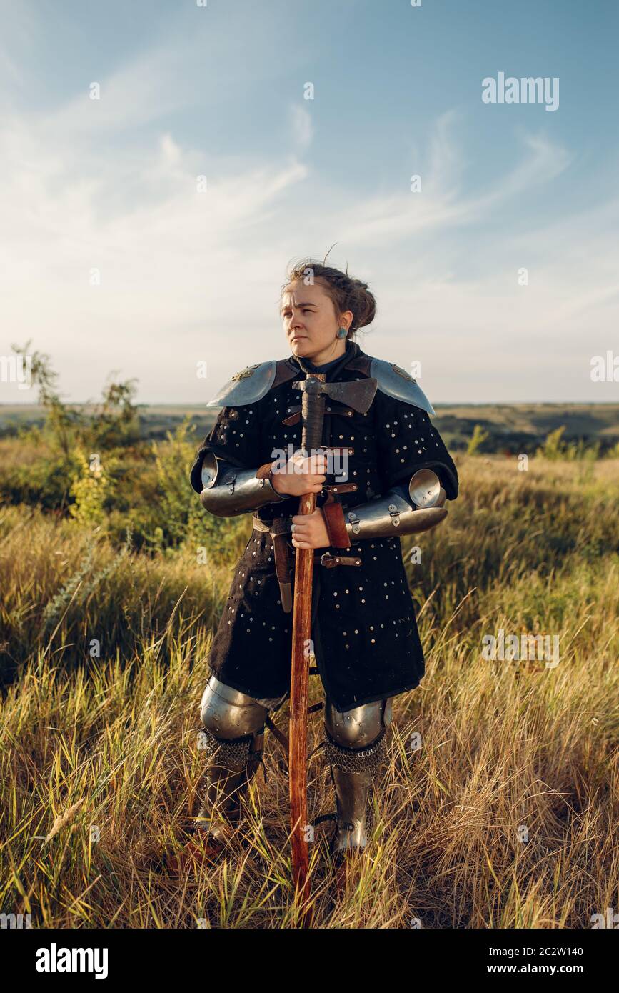 Female medieval knight poses in armor opposite the castle, great ...
