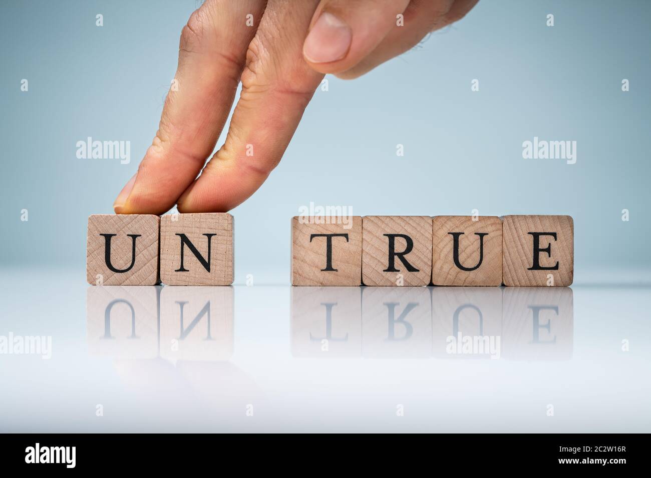 Fingers Over The Un True Blocks Against White And Blue Reflective ...