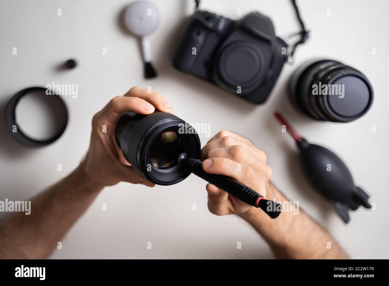 High Angle View Of Man Cleaning Camera Lens Element Stock Photo - Alamy