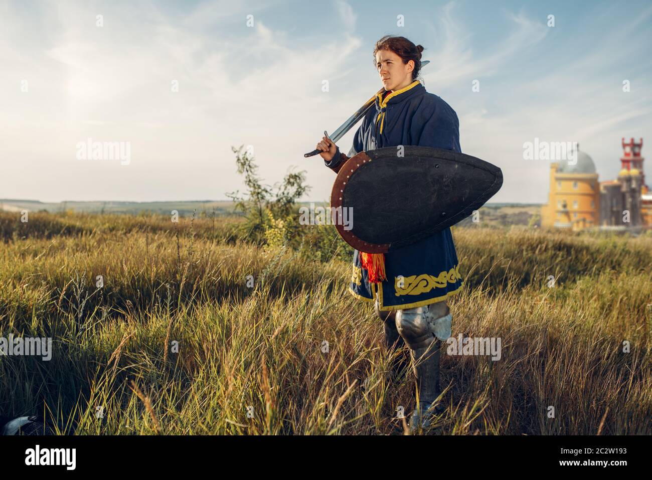 Female medieval knight poses in armor opposite the castle, great ...