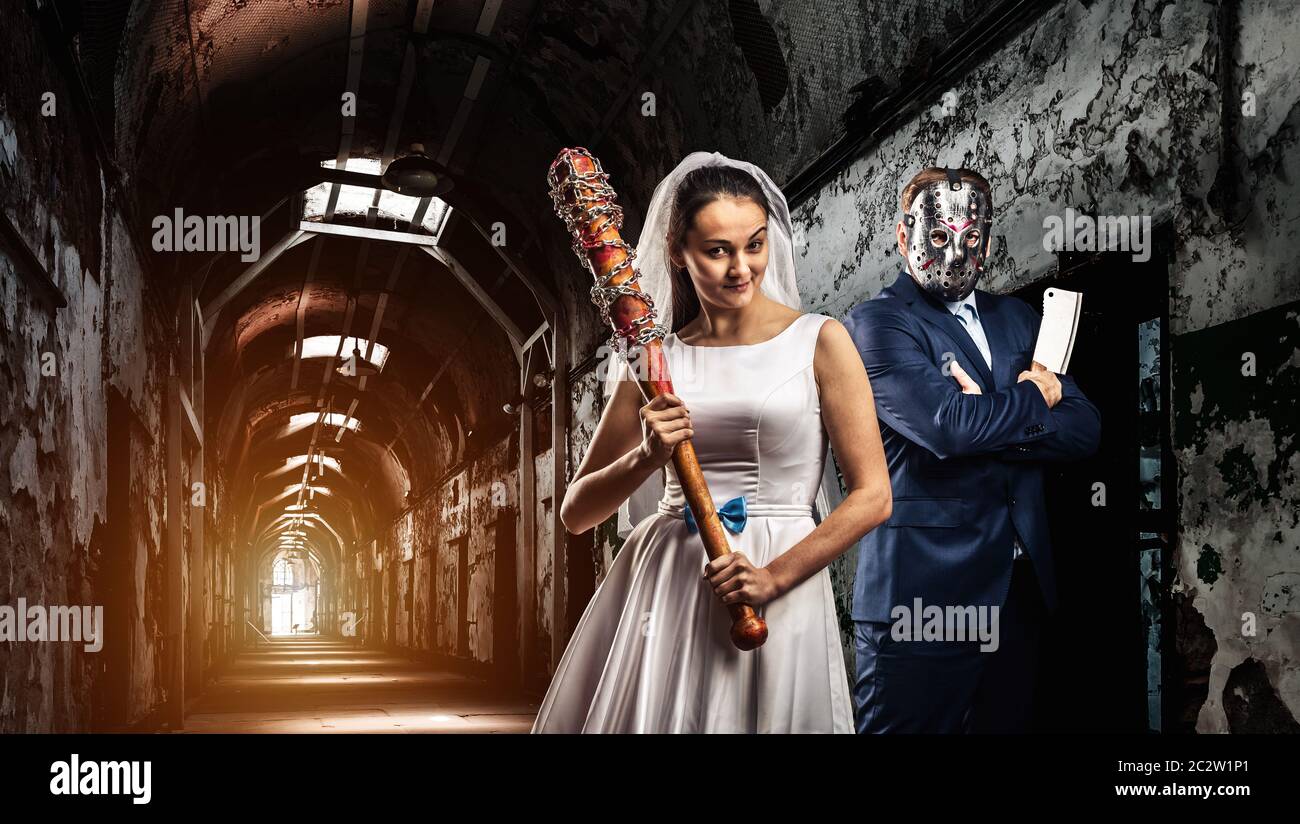 Newlyweds maniacs, an interior of old prison on background. Couple with ...