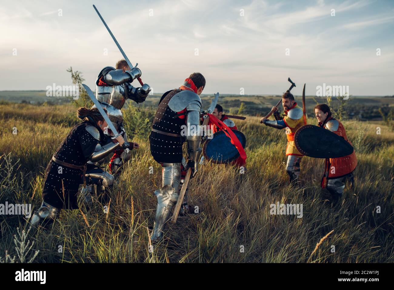 Medieval knights in armor and helmets fight with sword and axe. Armored ...