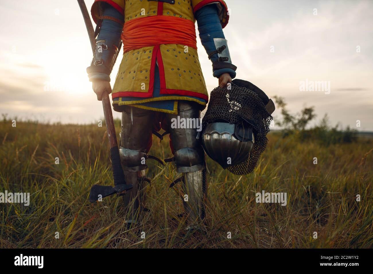 Medieval knight in armor holds axe and helmet, great tournament ...