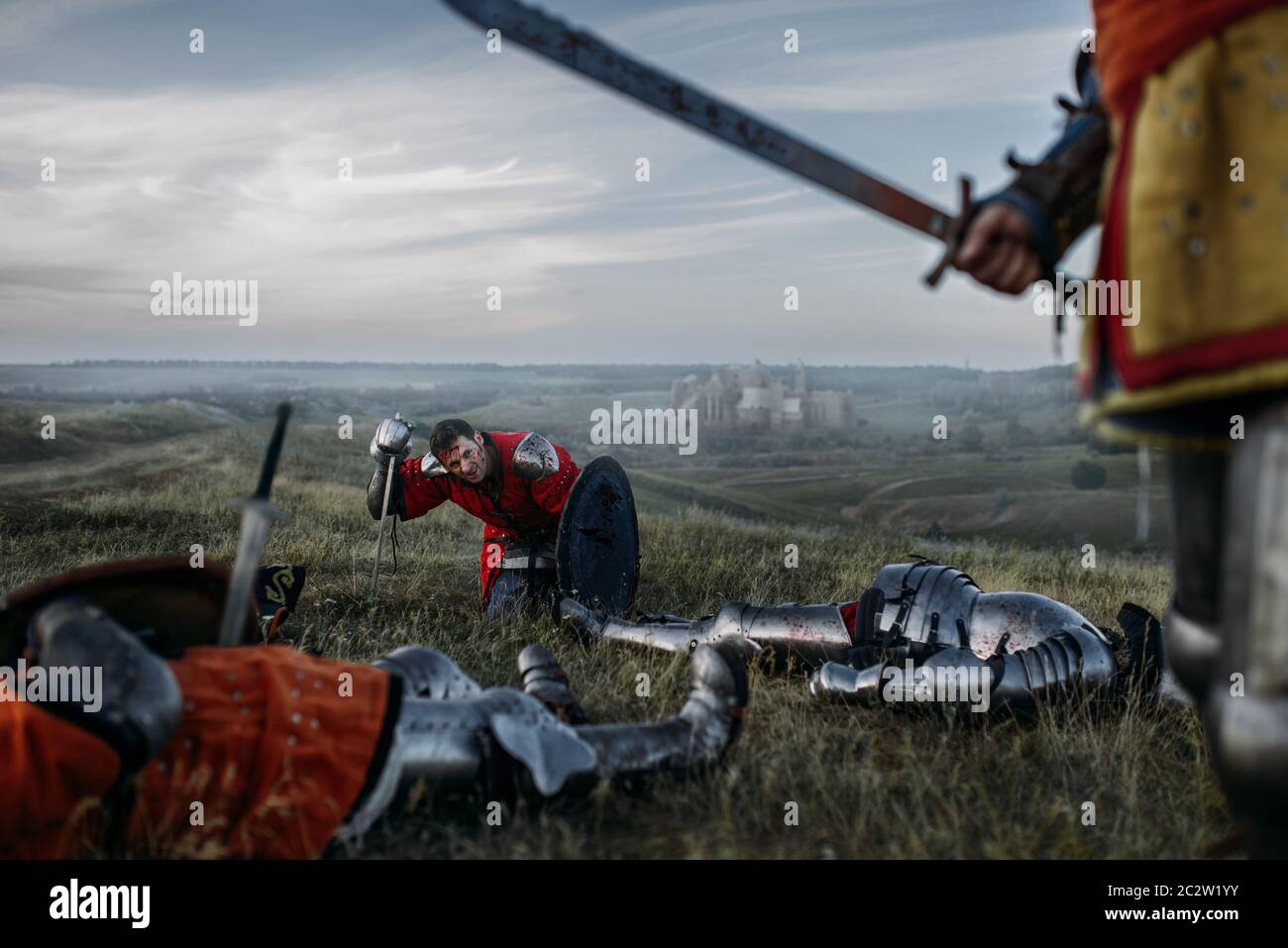 Old medieval knight in armor looks at the dead after great battle ...