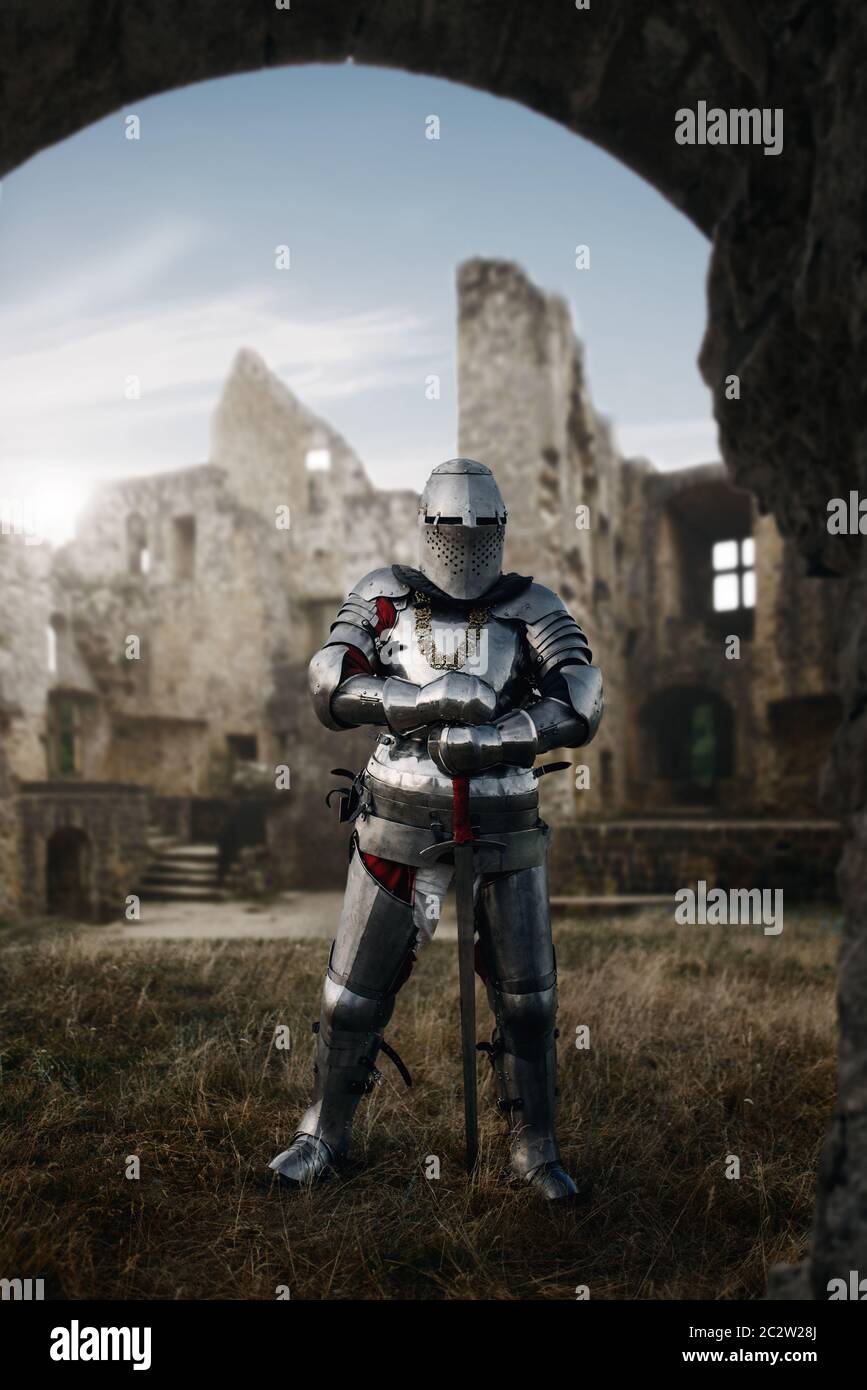 Medieval knight in armor and helmet poses in castle, great battle ...