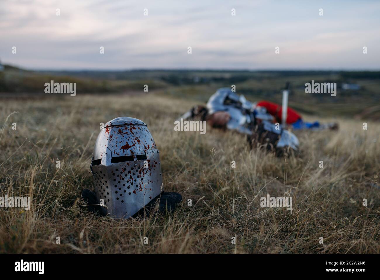 Helmet in blood, dead medieval knight on background, great tournament ...