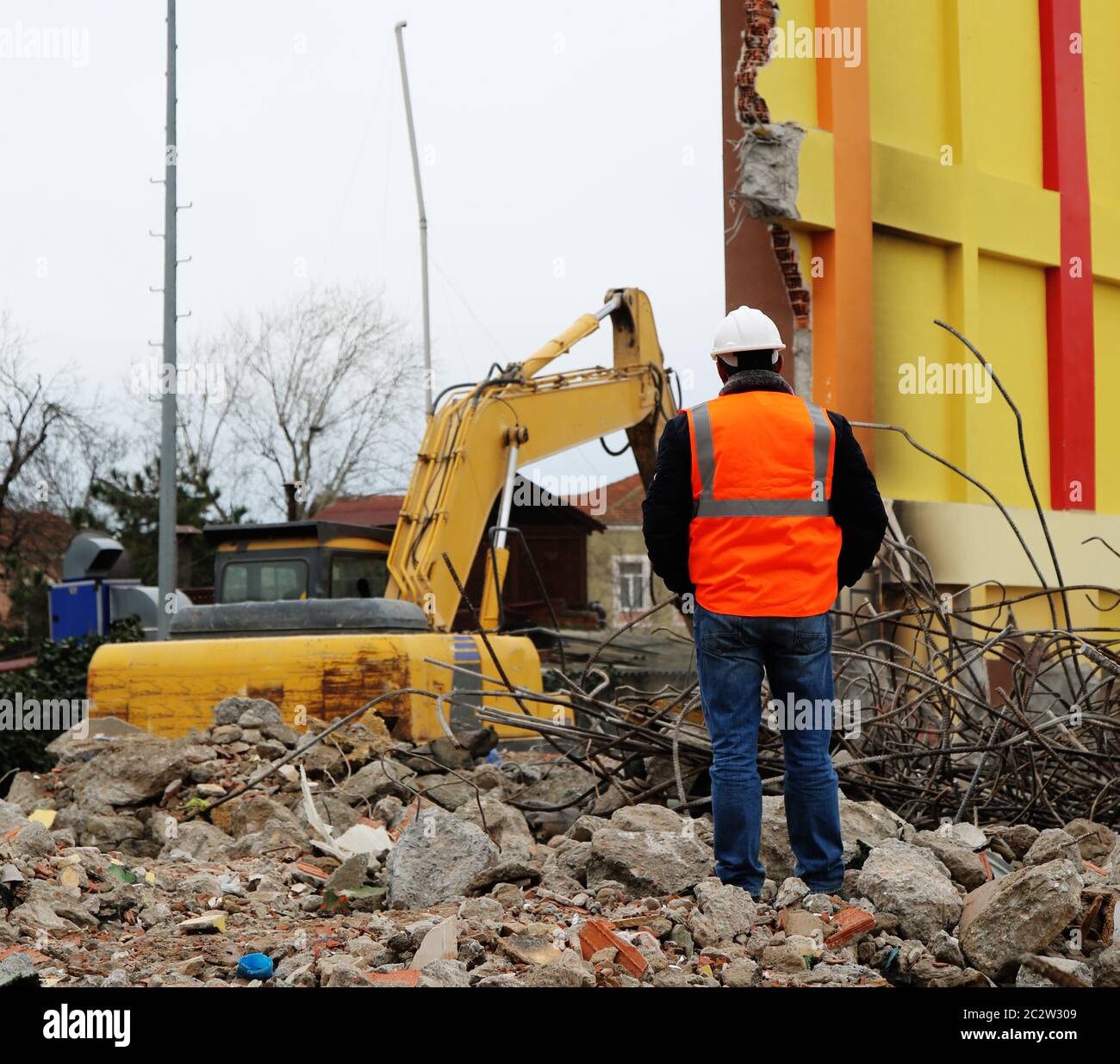 Engineer mans in helmet and jacket controlling outdoor construction ...