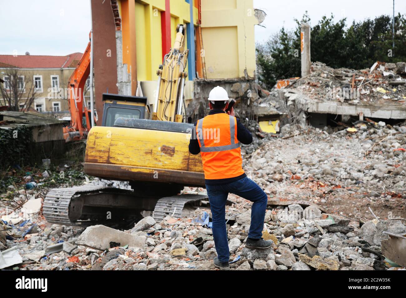Engineer mans in helmet and jacket controlling outdoor construction ...