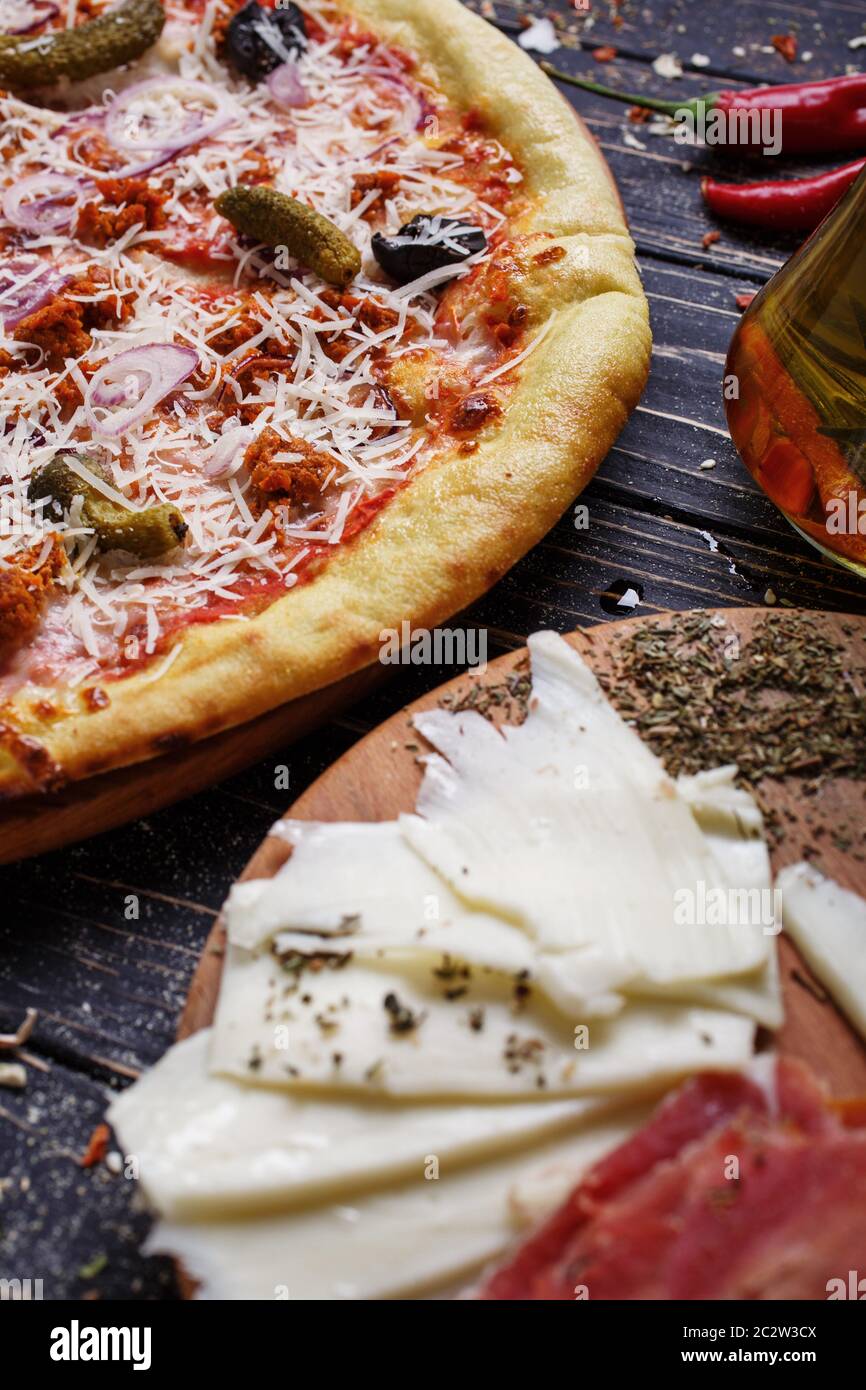 Traditional Italian pizza on a dark table with ingredients. Pizza menu ...