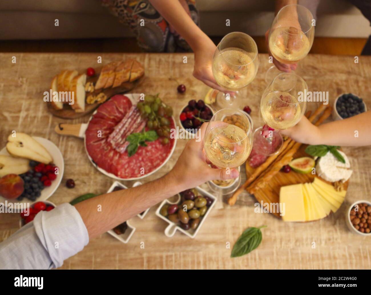 Hands of a group of people cheering with white wine Stock Photo - Alamy