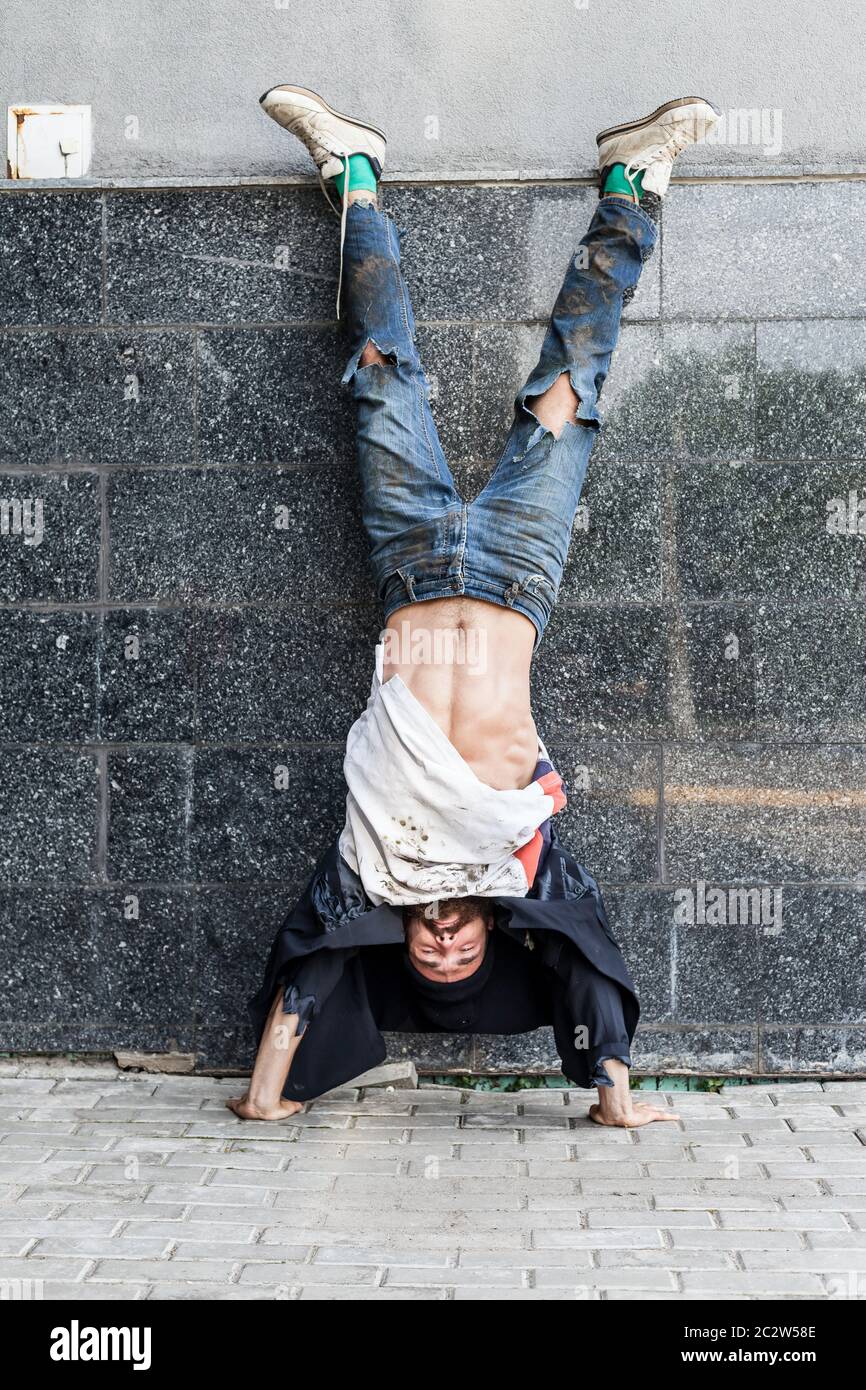 Young vagrant doing handstands on the street Stock Photo - Alamy