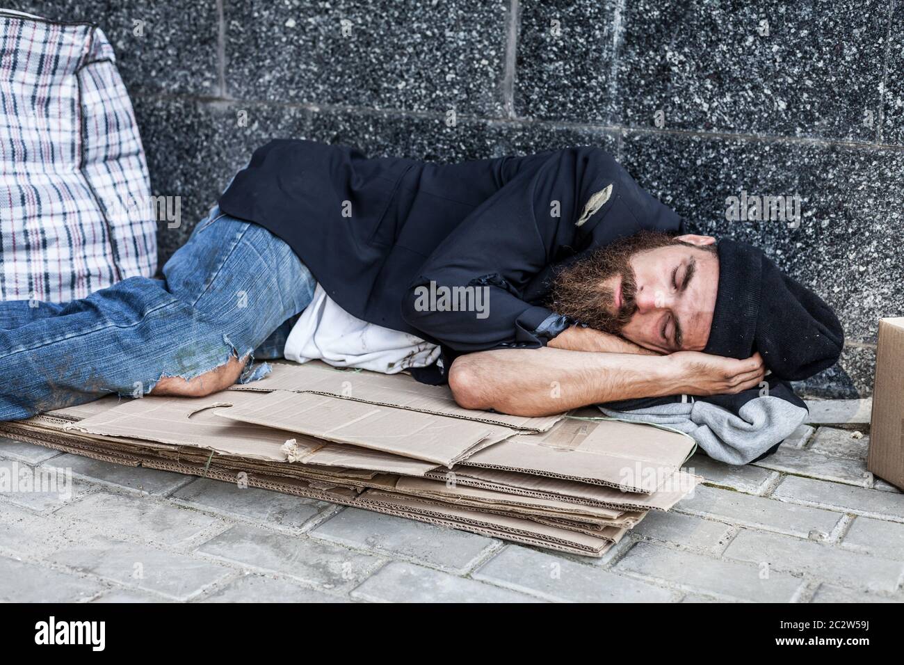 Homeless is sleeping on the cardboard on the street Stock Photo - Alamy