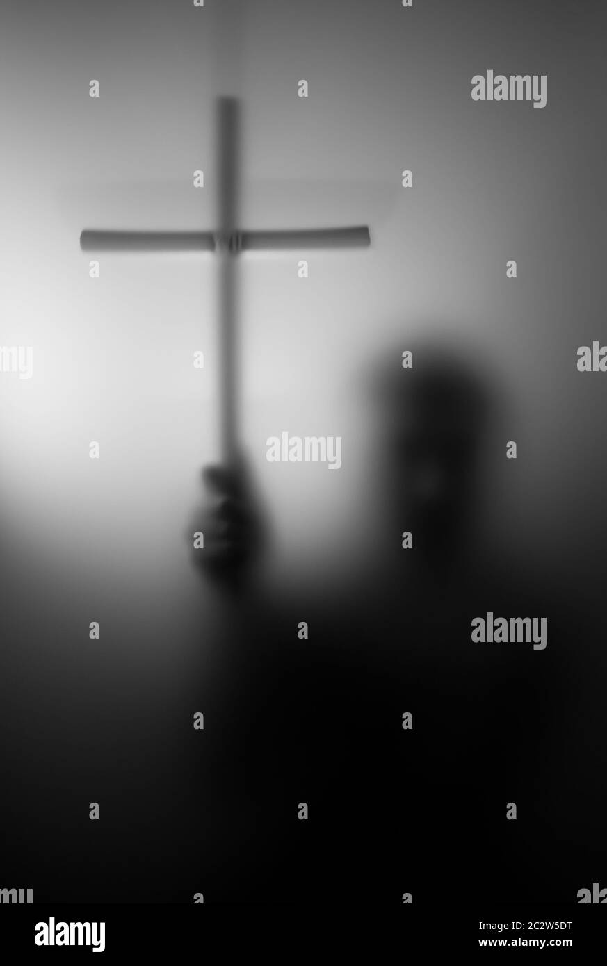 Blurred silhouette of saint with cross in the dark Stock Photo - Alamy