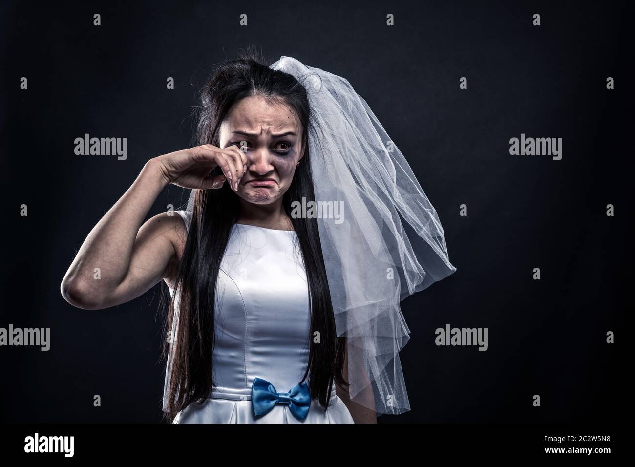 Bride with tearful face, unhappy marriage. Studio photo shoot on black ...