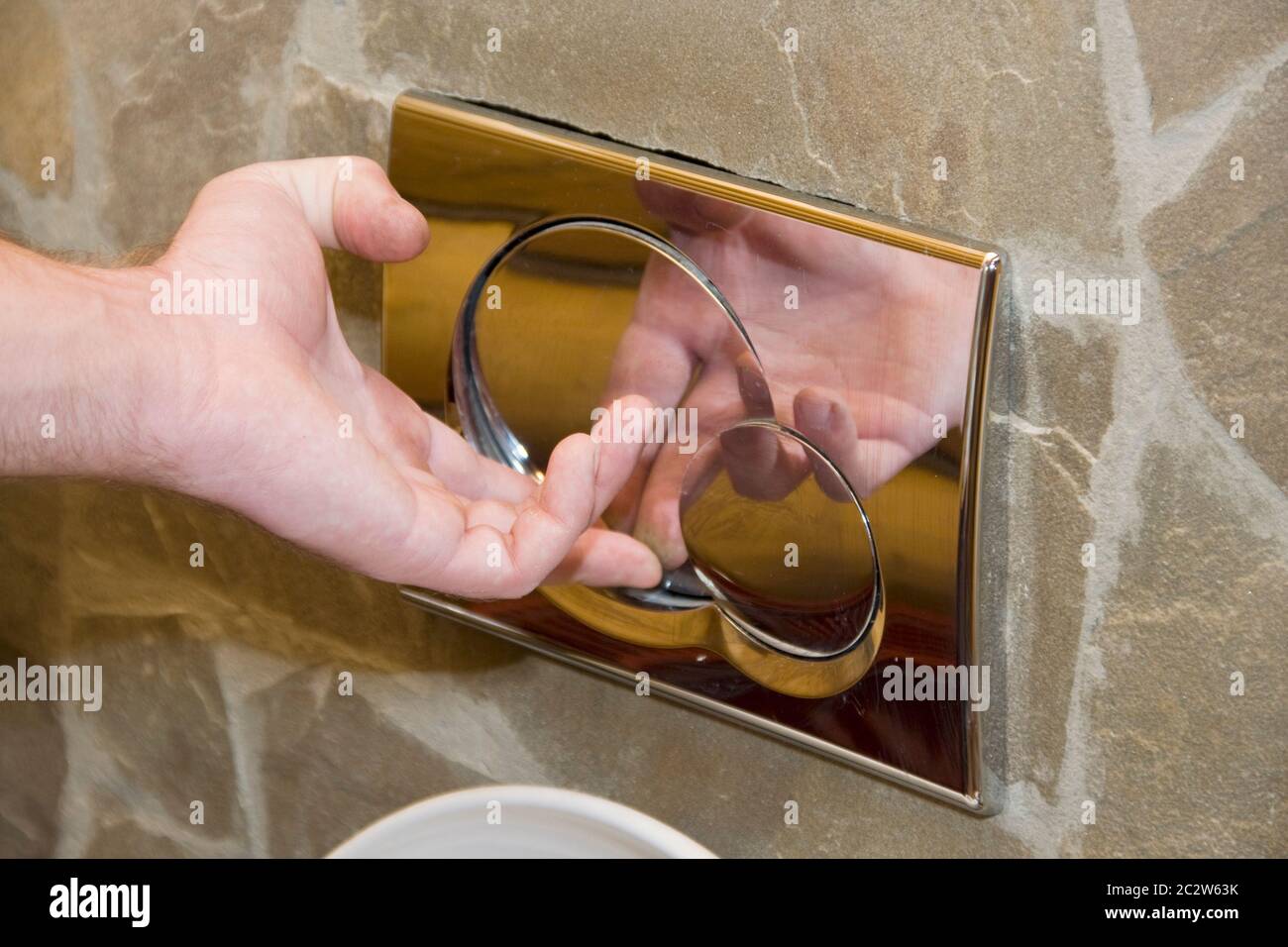Pressing the flush button on the wall Stock Photo - Alamy