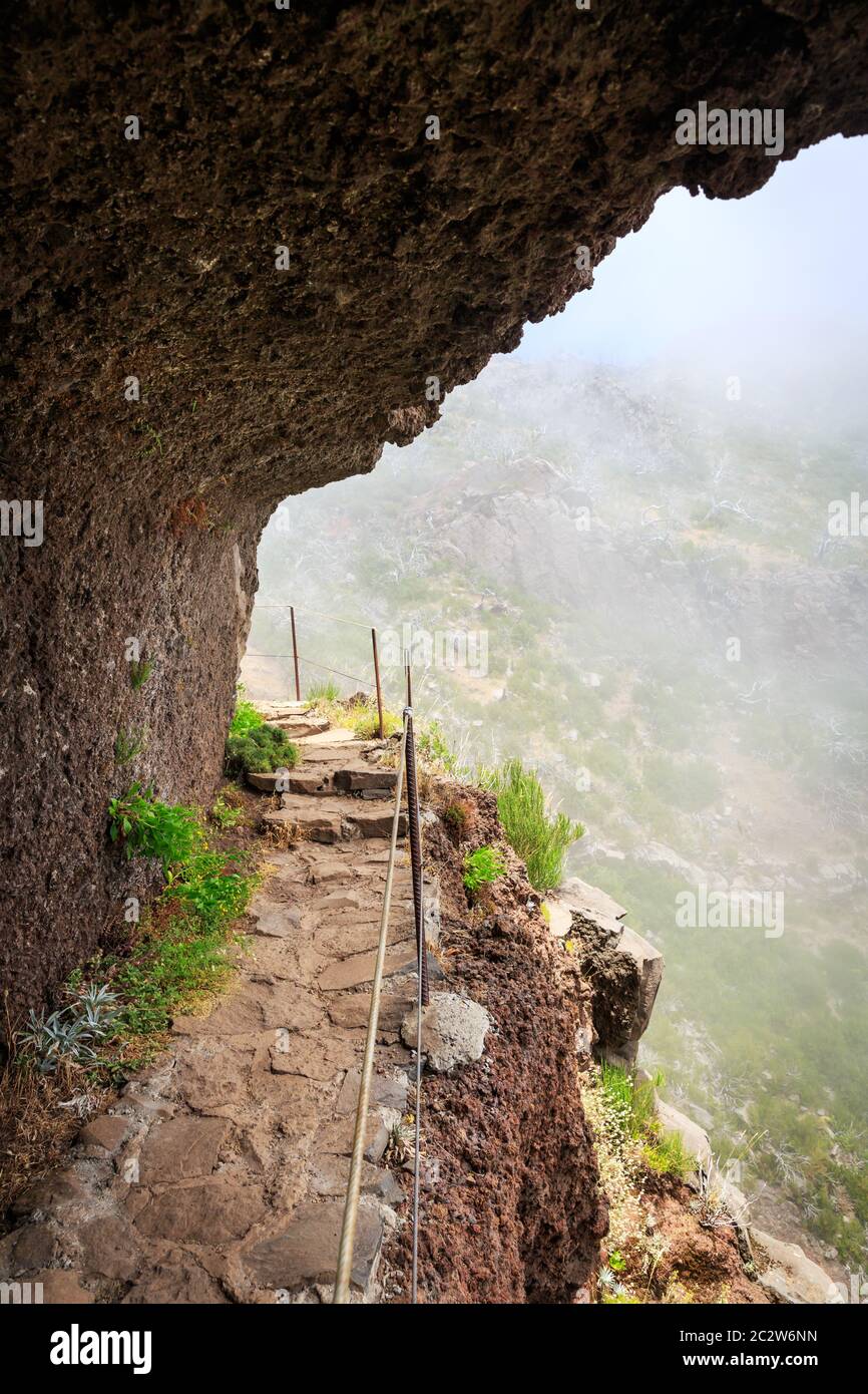 Mountains in clouds with path with handrail Stock Photo - Alamy