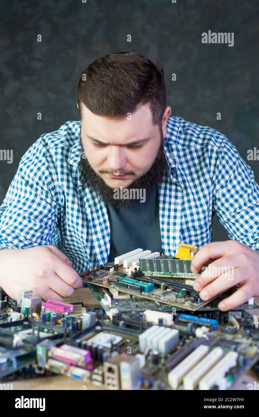 Service engineer work with broken computer motherboard. Electronic ...