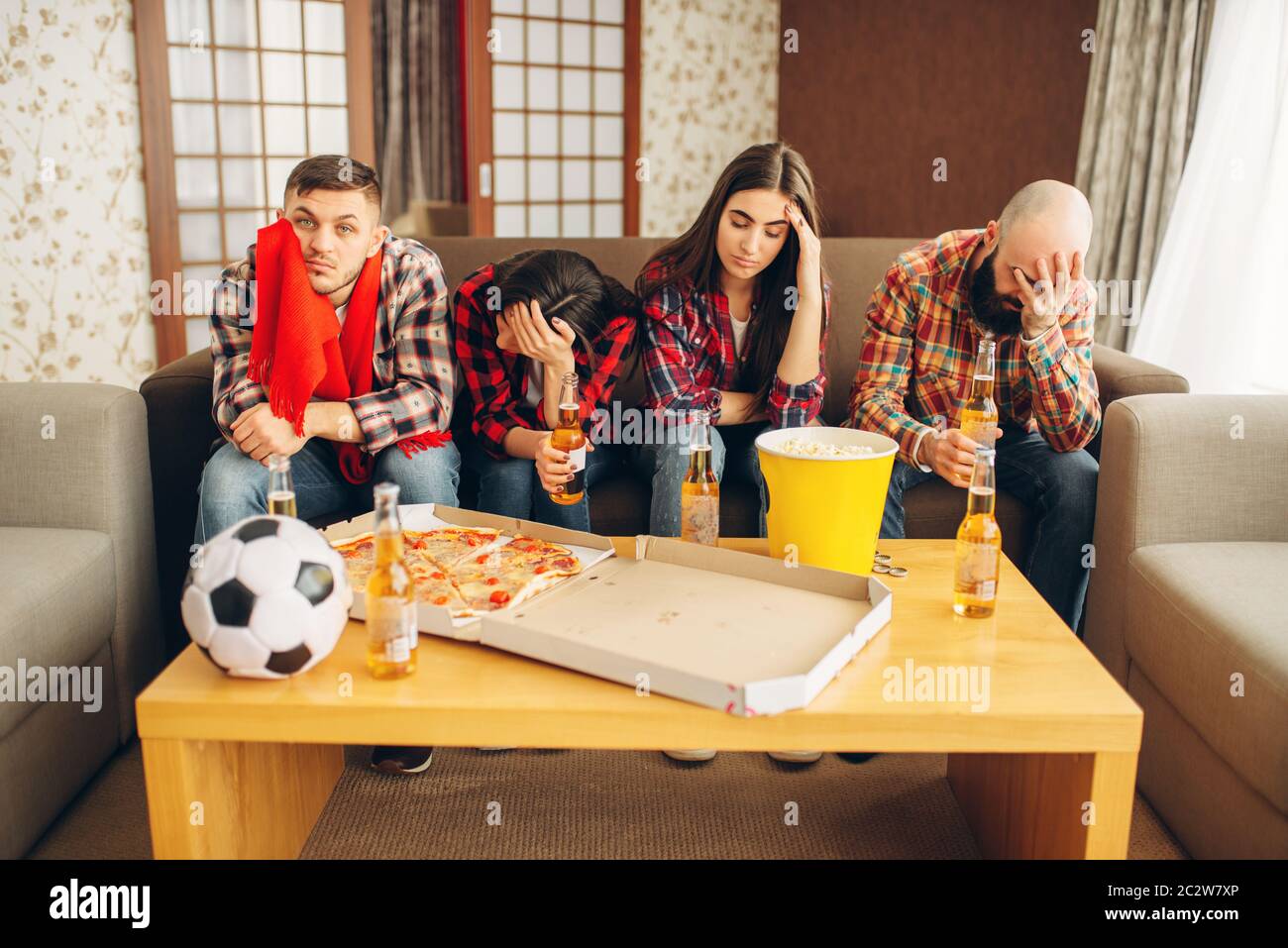 Football fans sadly wathing tv broadcast at home. Group of people ...
