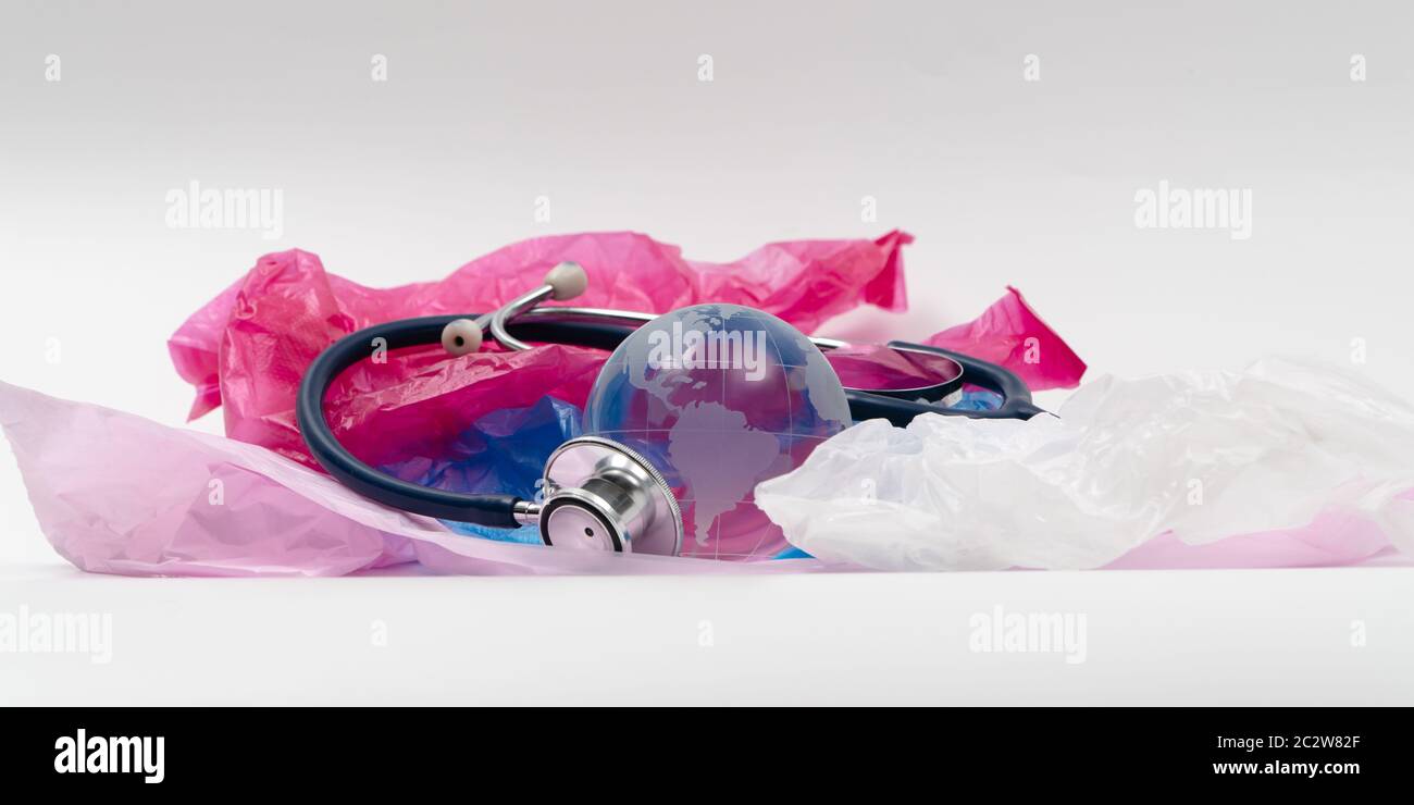 Crystal globe and Stethoscope on plastic bag. Plastic waste overflows ...