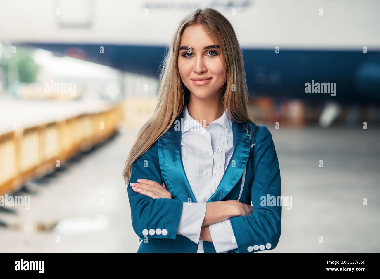 Attractive stewardess in uniform poses against airport building. Air ...