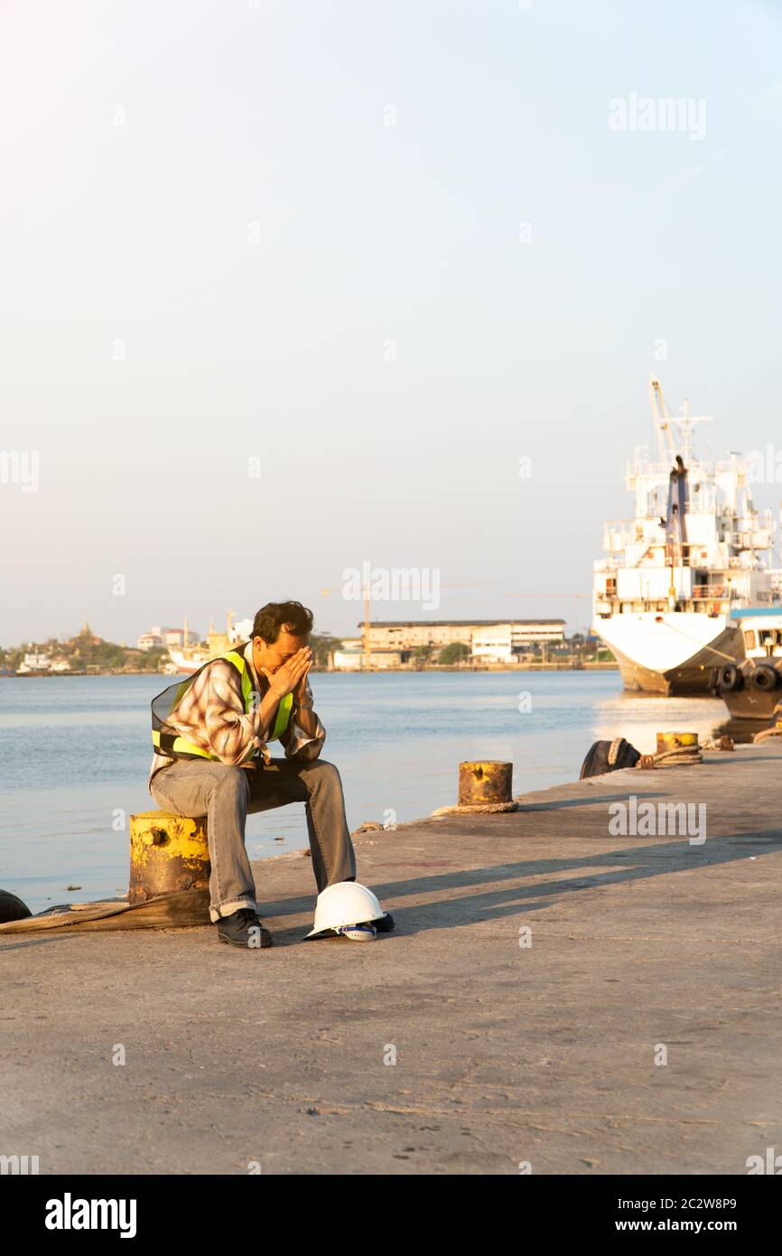 Engineers sitting and wearing a safety helmet. He felt tired ...