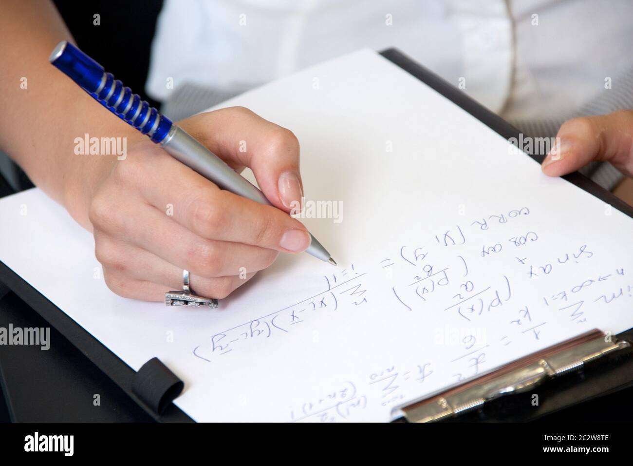 Student in classroom writing mathematics formulas Stock Photo - Alamy