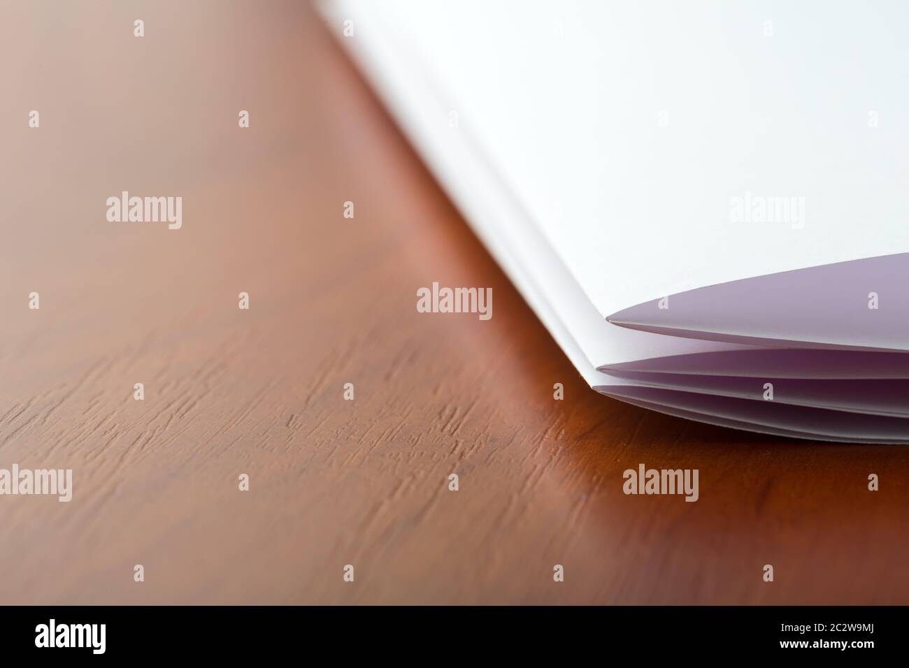 Macro of closed white sheet of paper lies on a wooden table Stock Photo ...