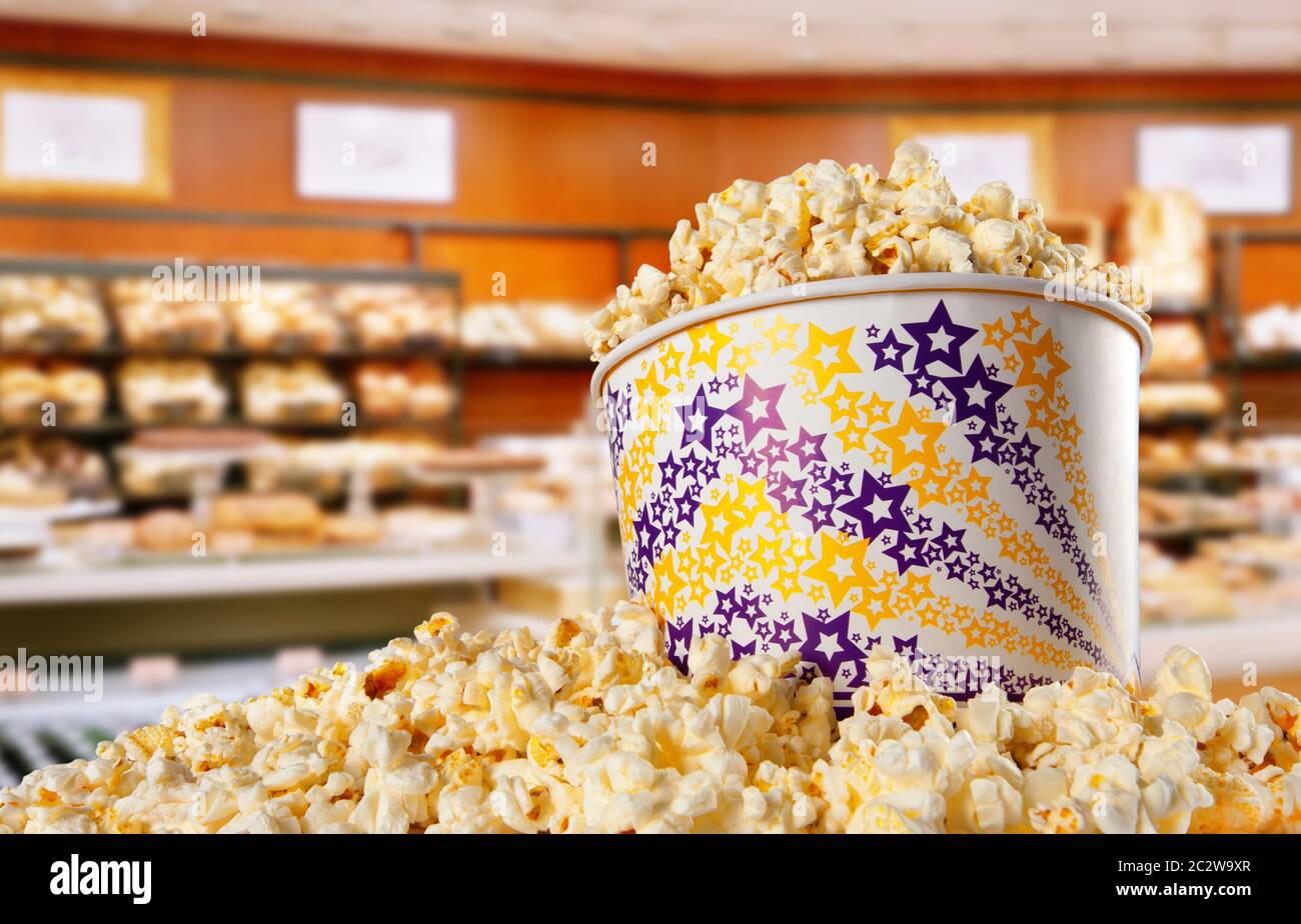 Shot of popcorn in large bucket against shop interior Stock Photo - Alamy