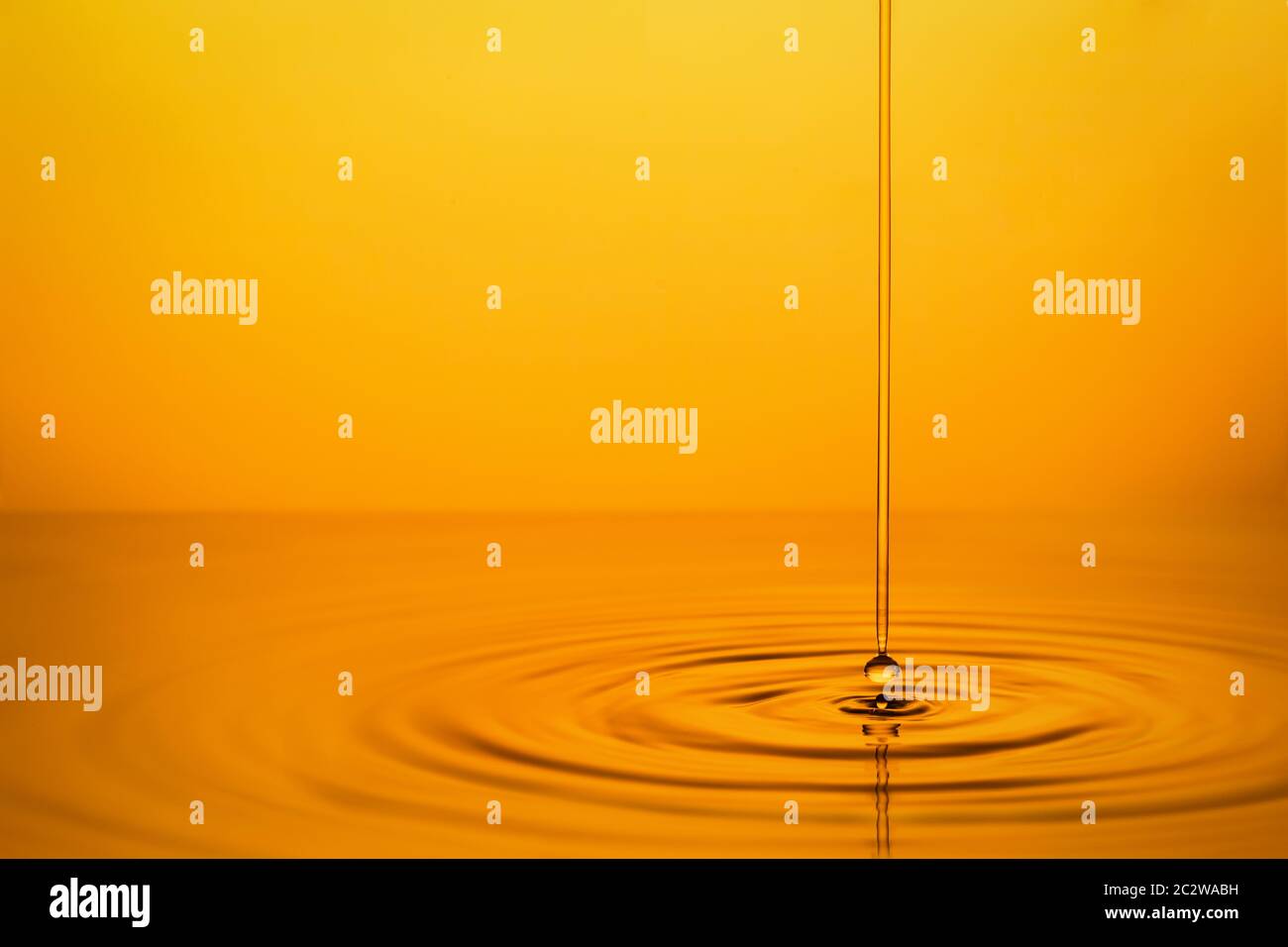 Ripple of the golden surface of yellow liquid with drops Stock Photo ...