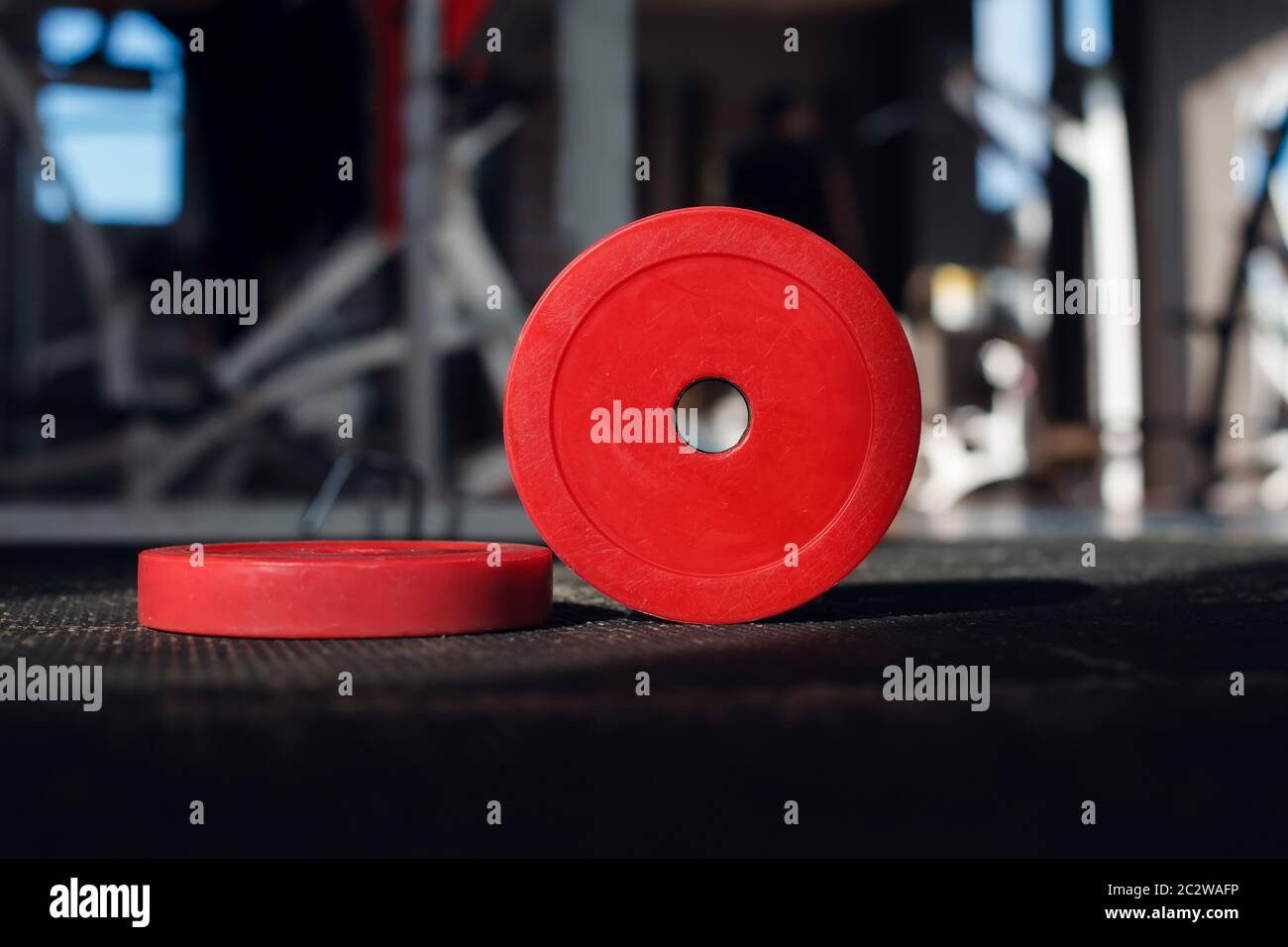 Red weight plates on the floor in the gym Stock Photo - Alamy