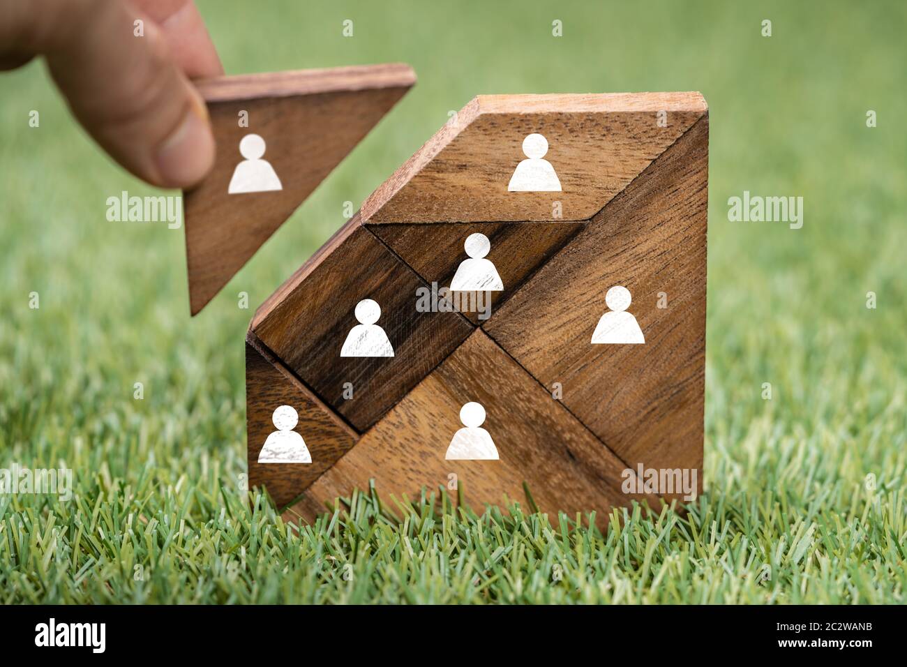 Person's Hand Building Tangram Square Block With Human Figures At ...